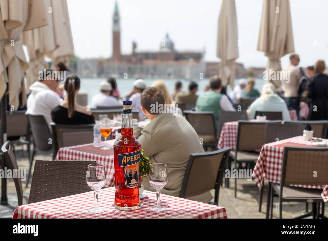 Venice, Italy - April 20 2025: Aperol bottle in busy waterfront cafe ...