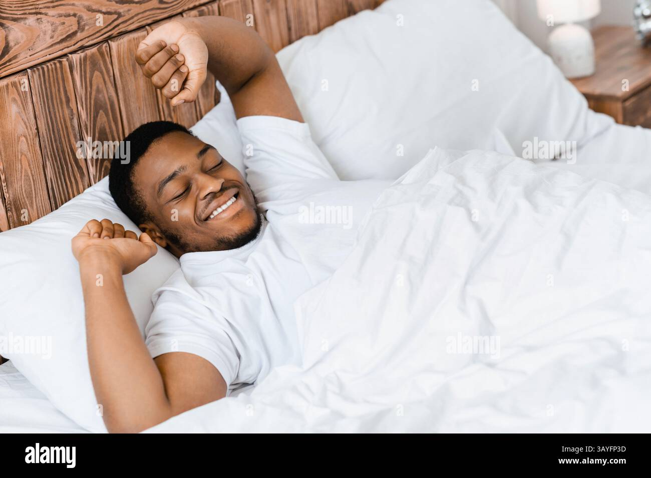Rested Black Man Waking Up Lying In Bed At Home Stock Photo - Alamy