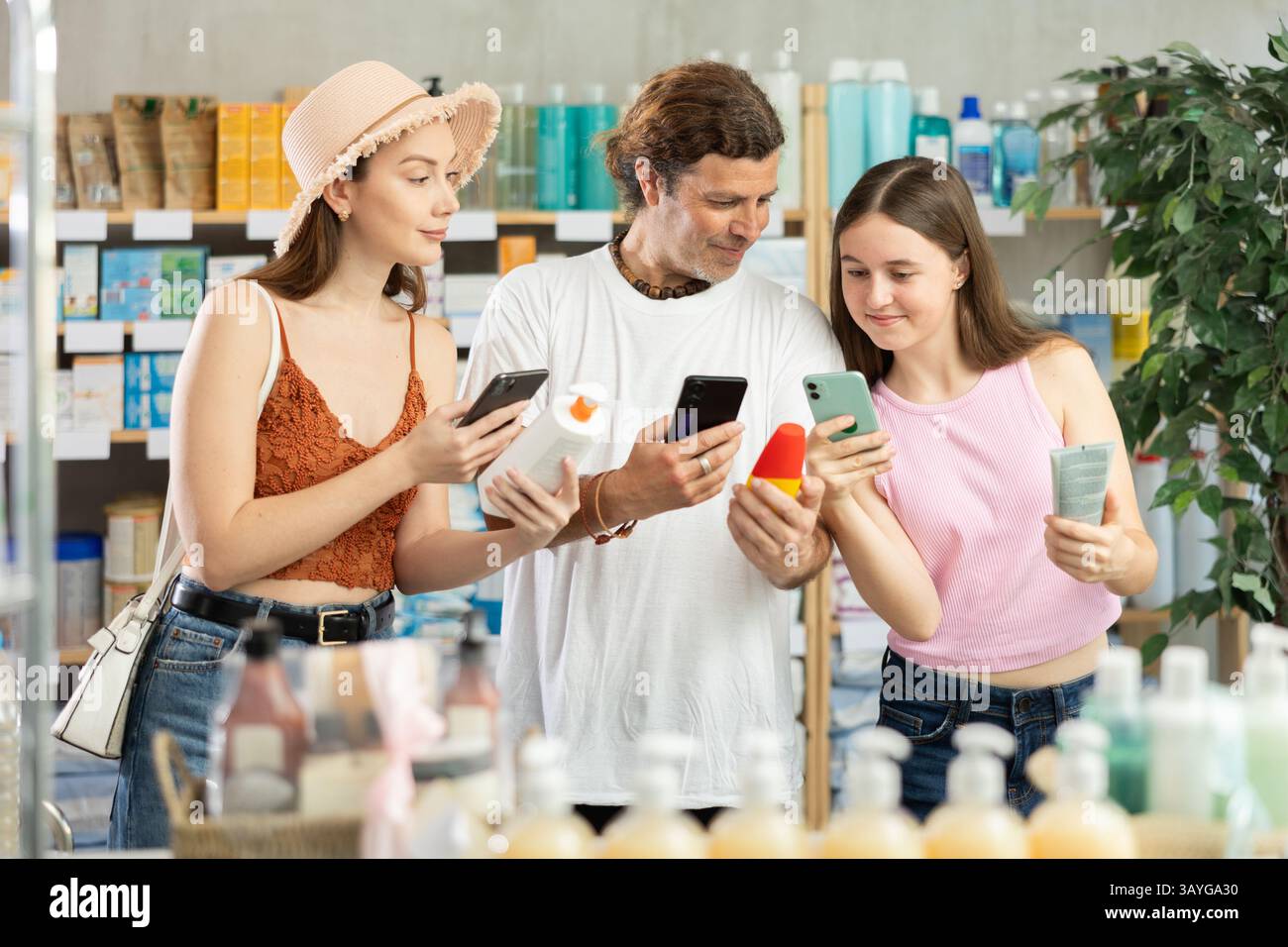 Father, mother and daughter choose sunscreen together - scan the QR ...