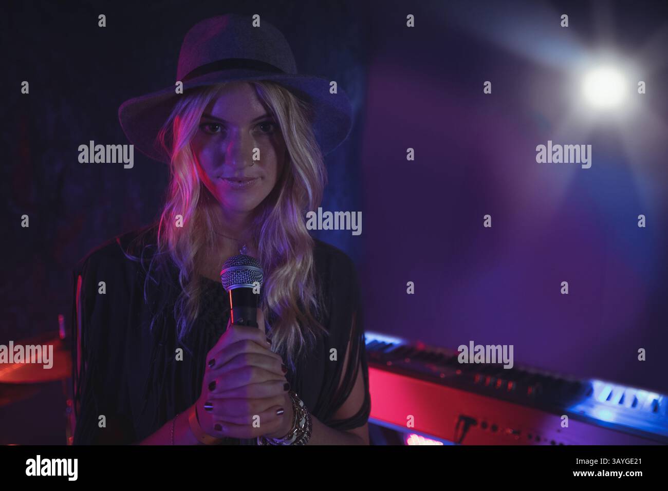 Female singer performing on indoor stage in small music venue, with ...