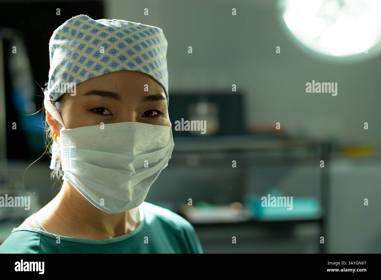 Asian female surgeon preparing for surgery in operating room with cap ...