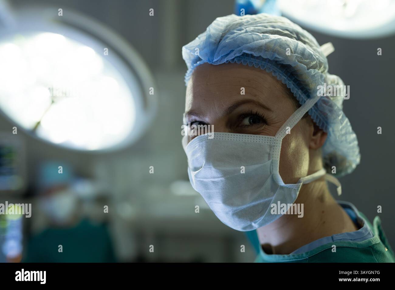 female surgeon smiling with eyes in operating room, with mask and ...