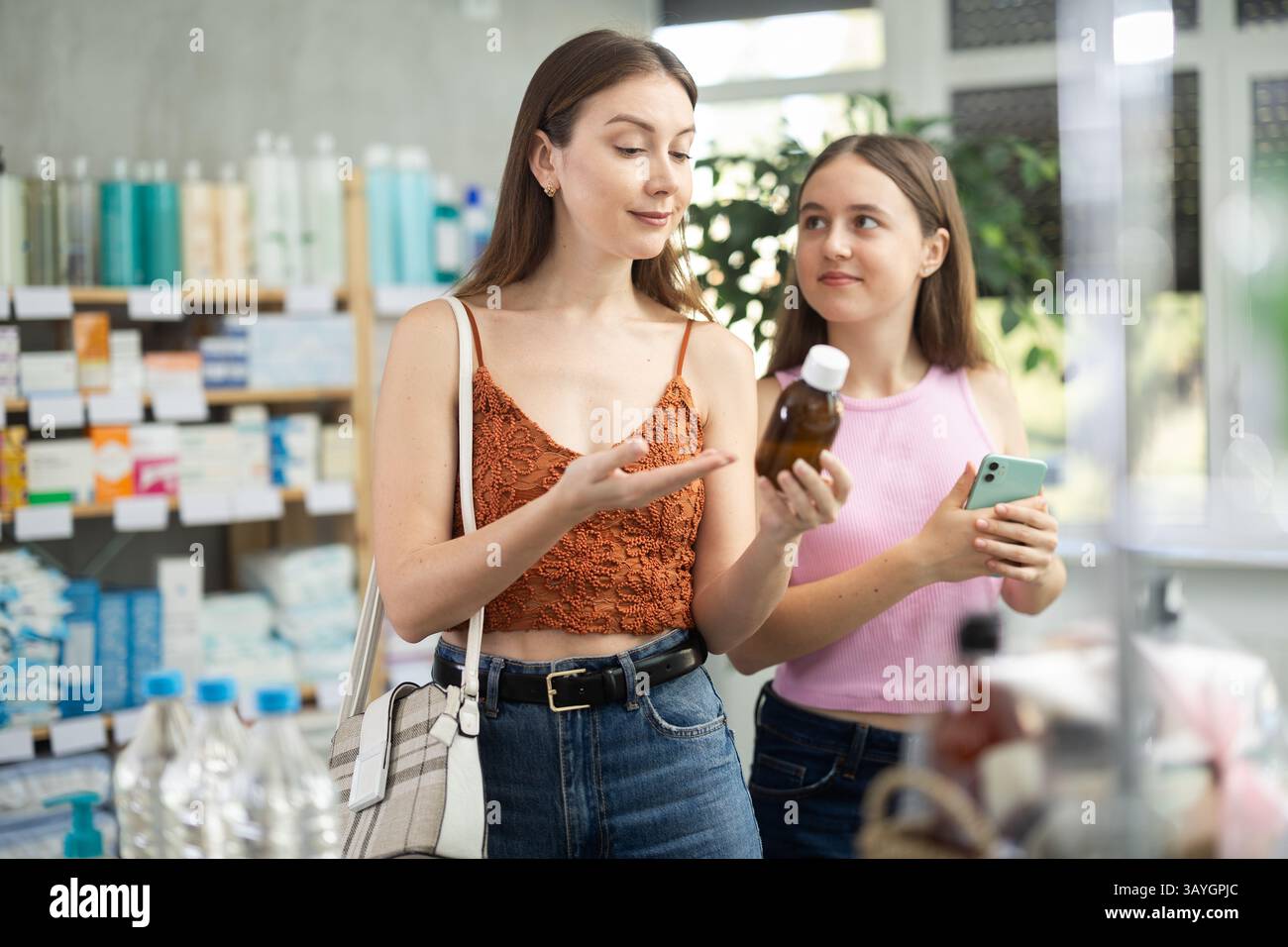 Mom and teen girl child buyer select expectorant syrup medicine Stock ...