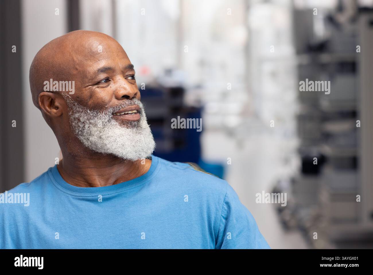 Senior African American man smiling gently and looking at lab equipment ...