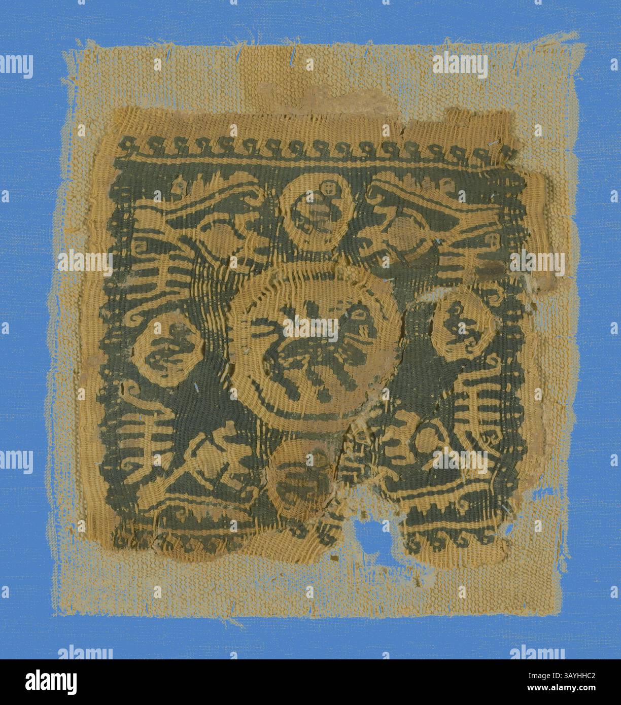 An intricate textile features a central lion motif surrounded by ...