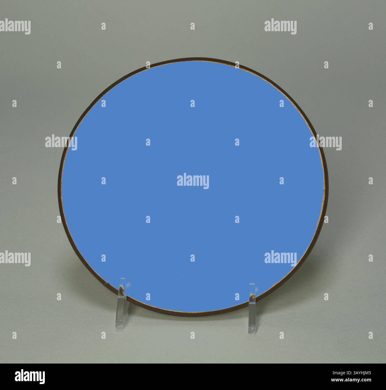 A round, smooth surface with a vibrant blue center, framed by a thin ...