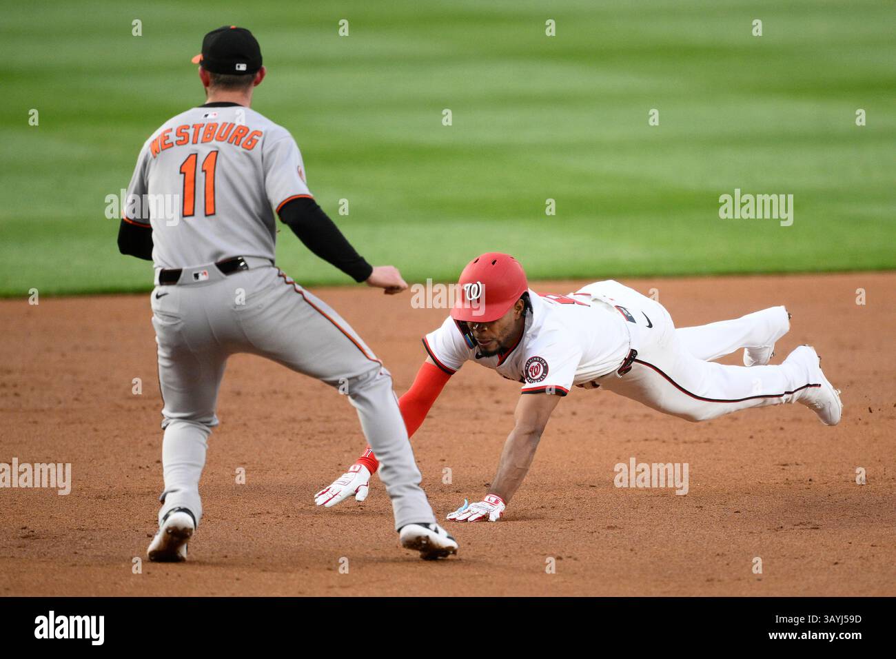 Washington Nationals' Jose Tena, right, slides towards third base for a ...