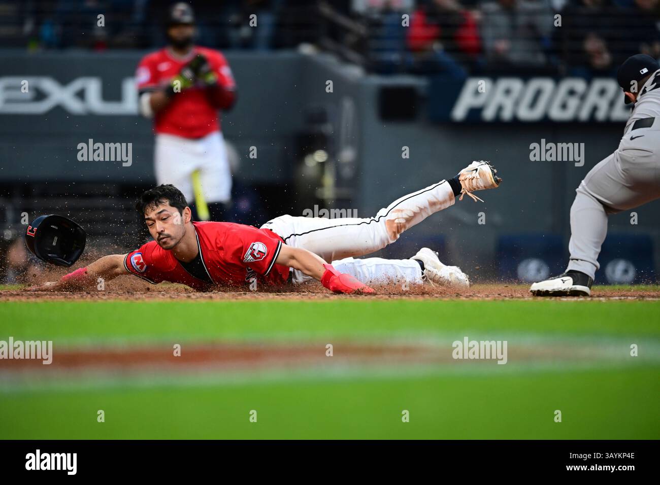 Cleveland Guardians' Steven Kwan slides to score a run on a pass ball ...