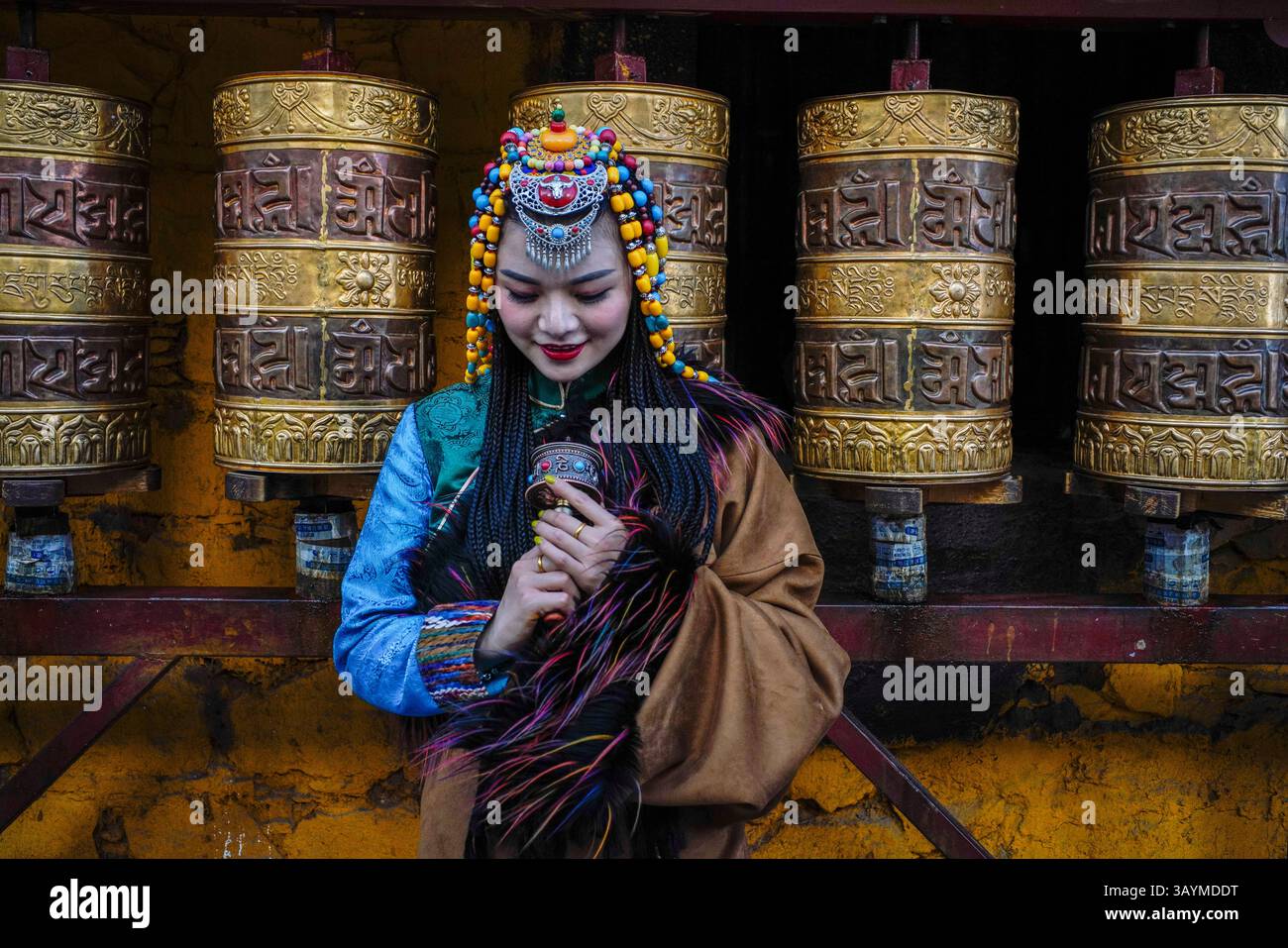 A line of Tibetan prayer wheels, or mani 'khor lo, displayed outside a ...