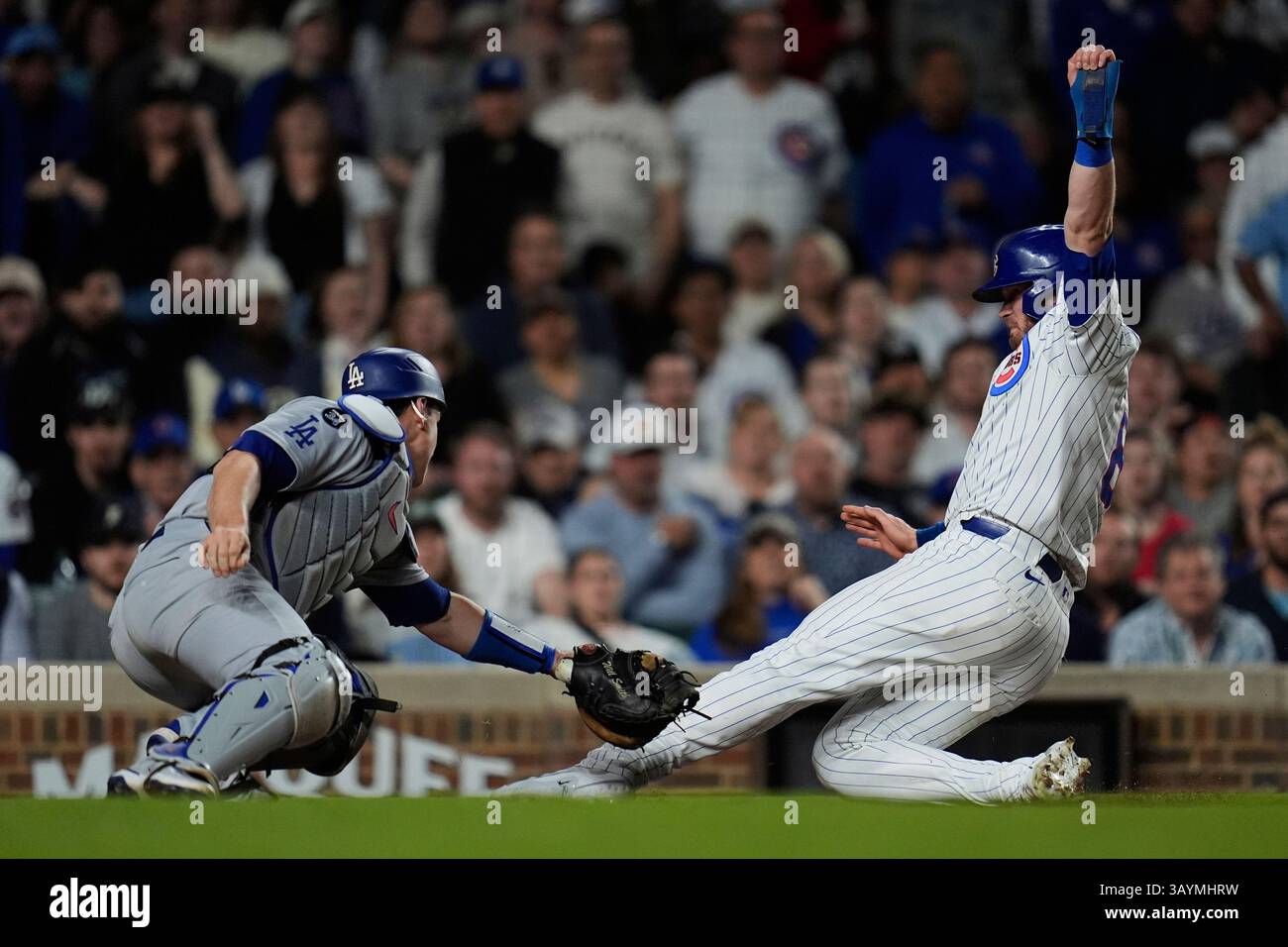 Chicago Cubs left fielder Ian Happ (8), right, is tagged out at home ...