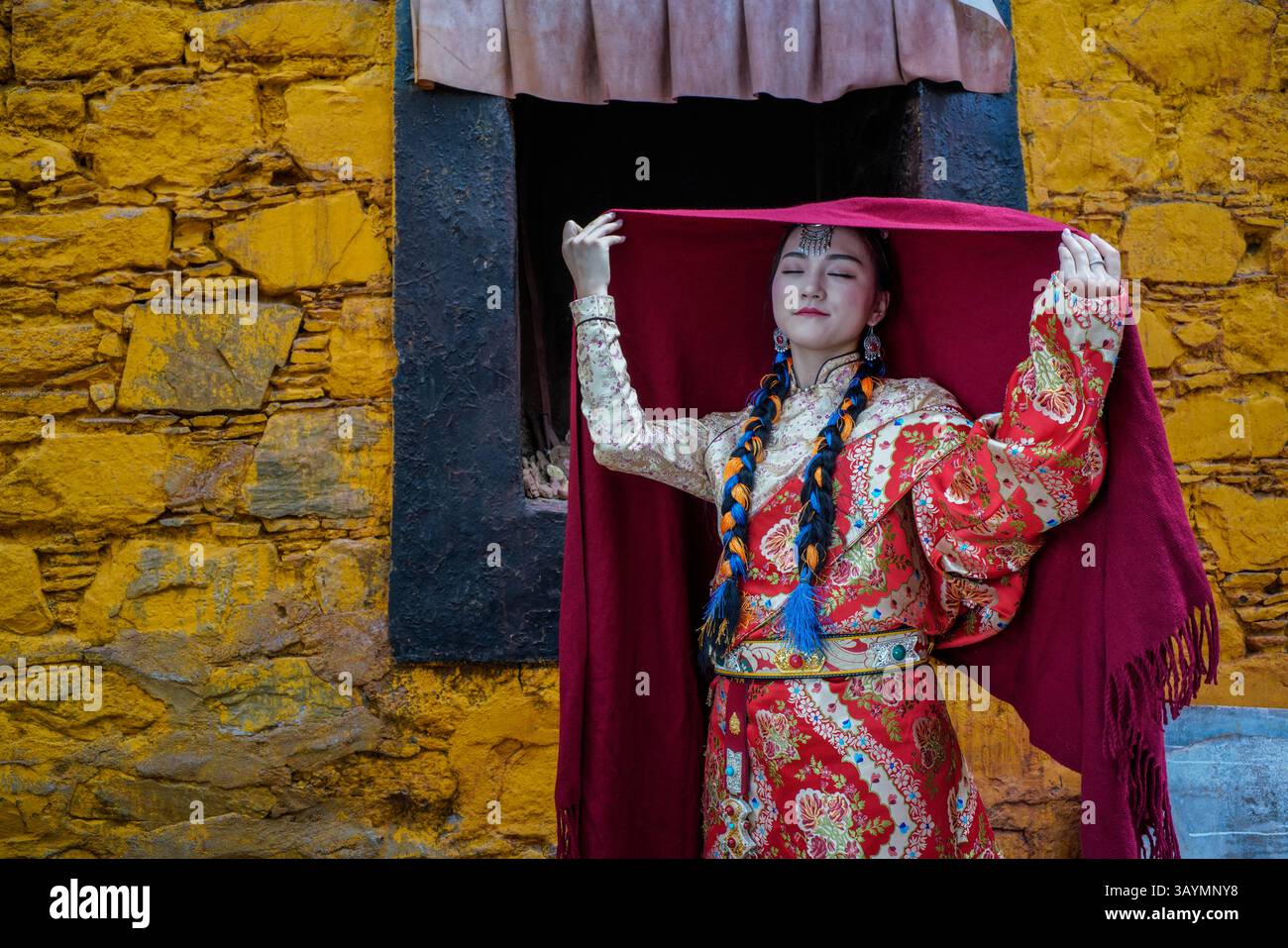 Young Chinese tourists dressed in stylized traditional clothing pose ...