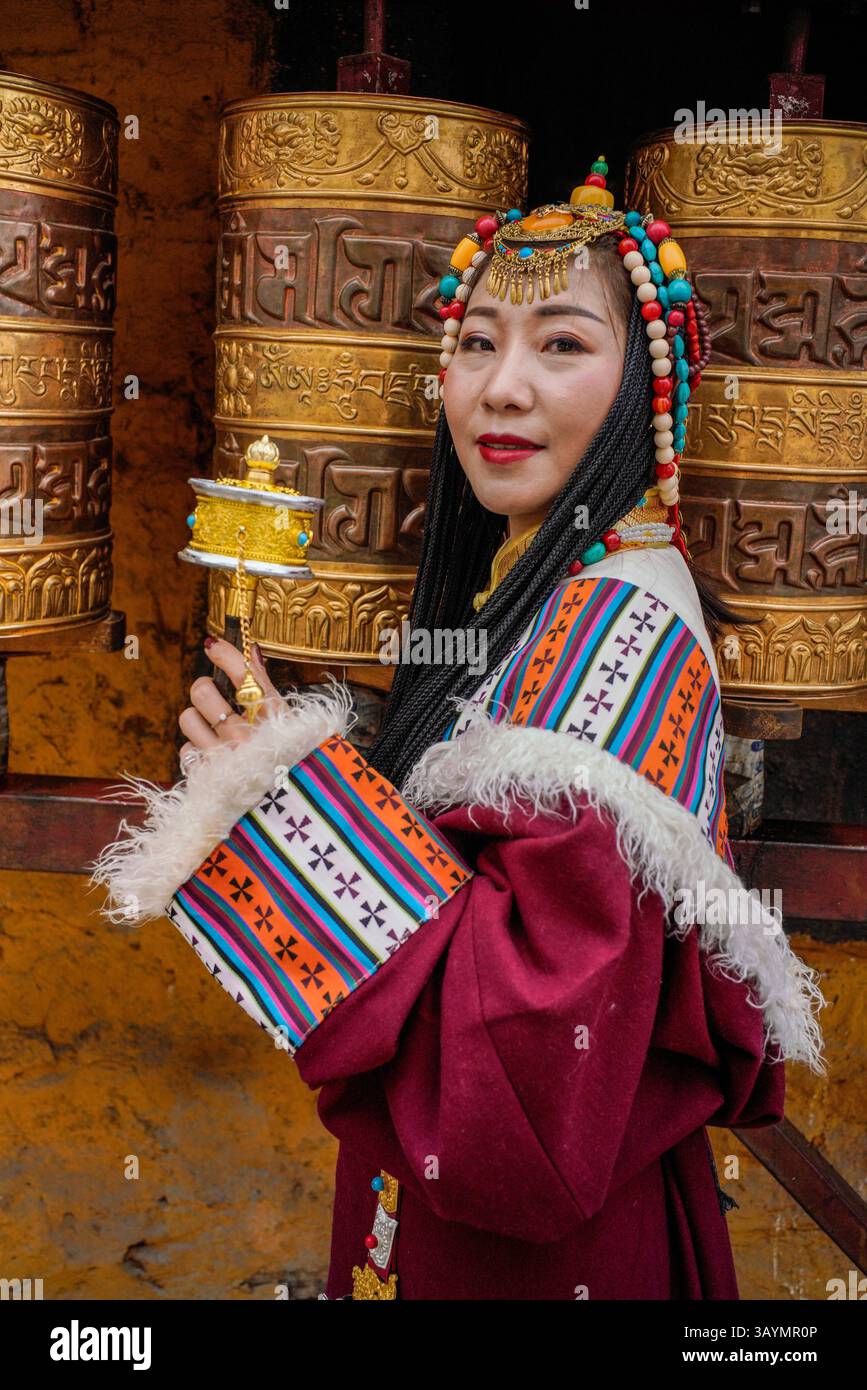 Young Chinese tourists dressed in stylized traditional clothing pose ...