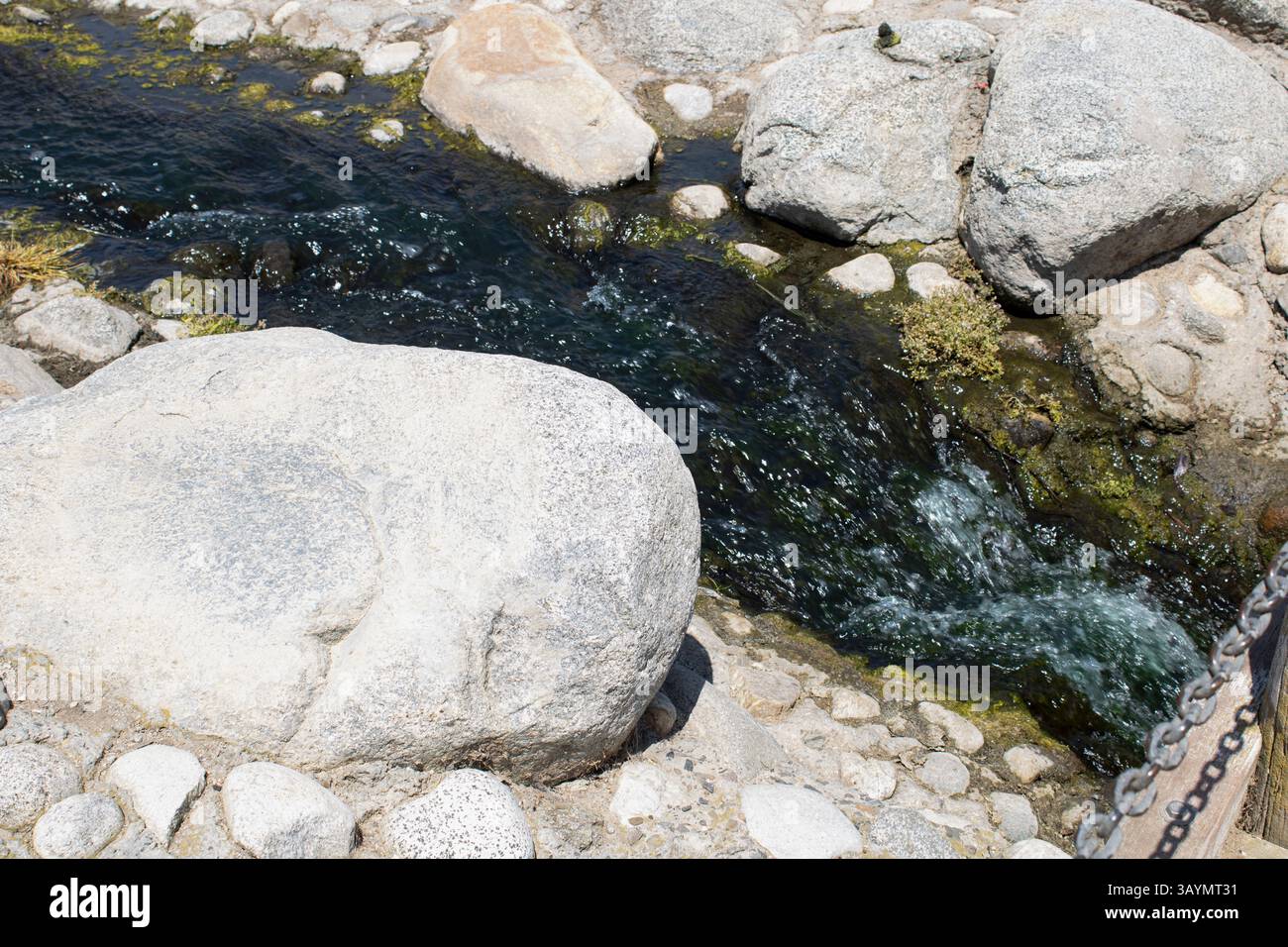 deep blue stream of water flowing through rocks Stock Photo - Alamy