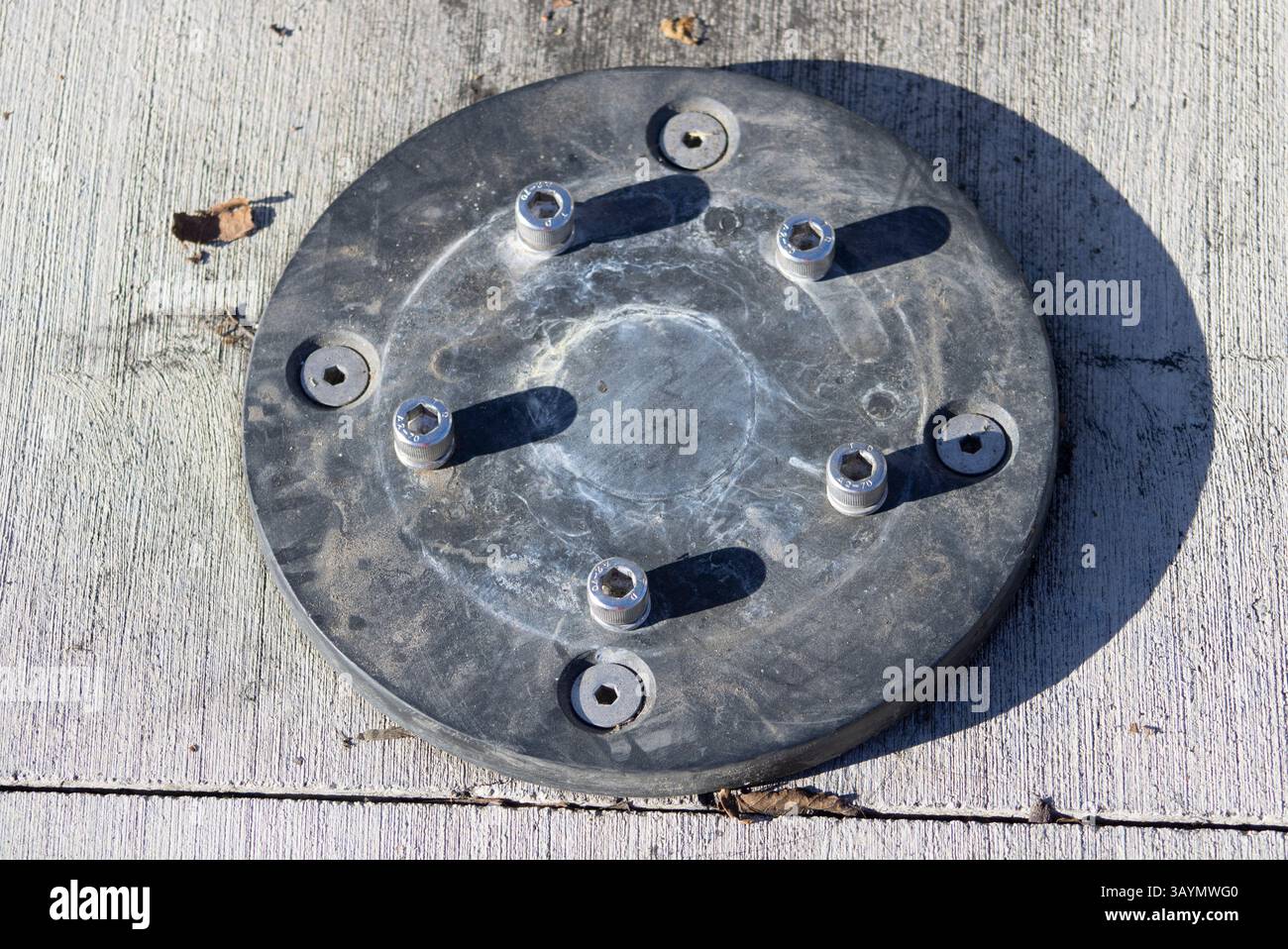 circular metal plate with screws on ground Stock Photo - Alamy