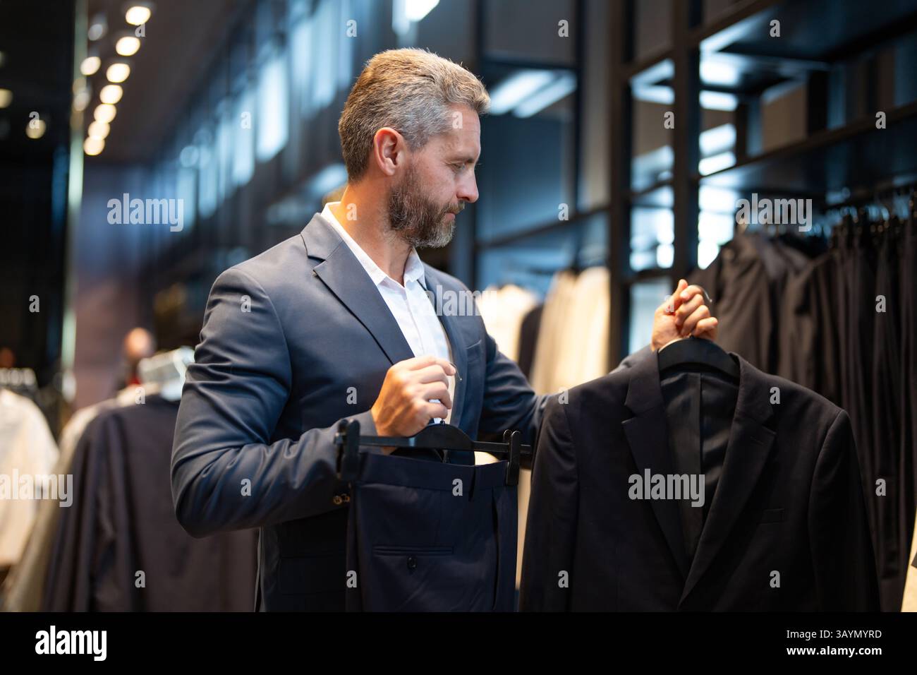 A man wears a classic tailored suit while shopping in a boutique. A ...