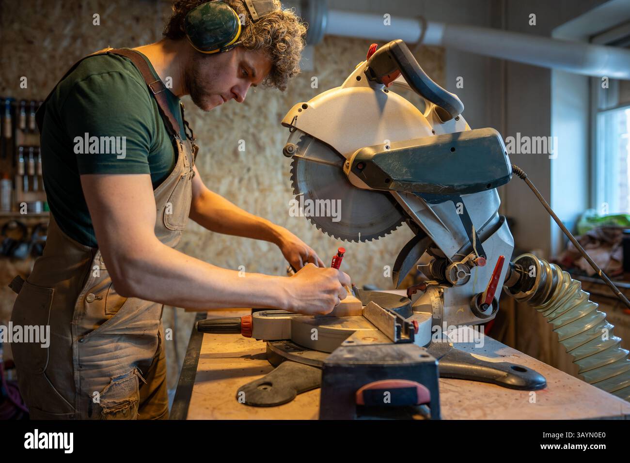 Skilled carpenter use miter saw, measure and trim wood beams in ...
