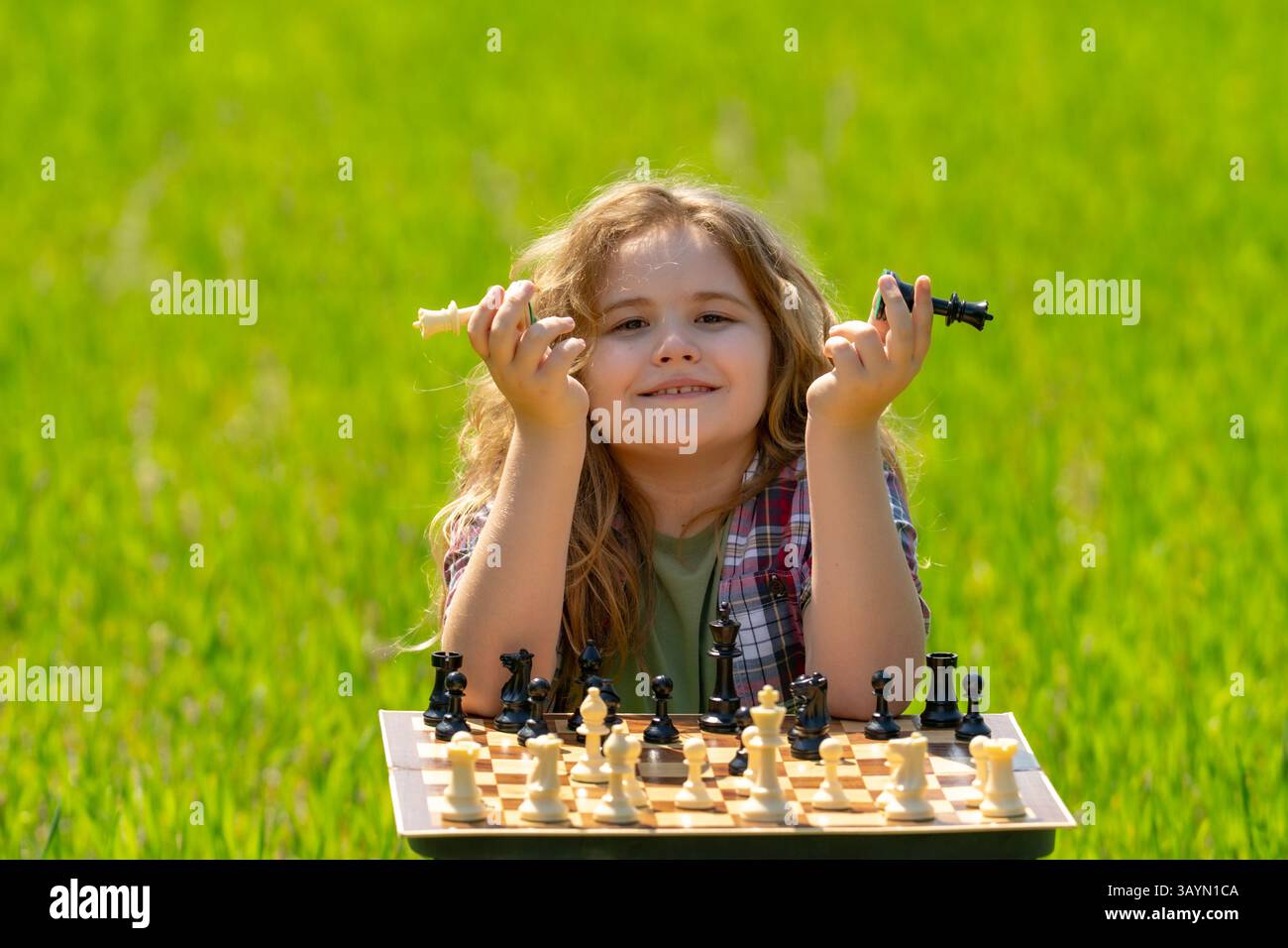 Kid plays chess. A clever blonde child thinks and playing chess. Kid ...