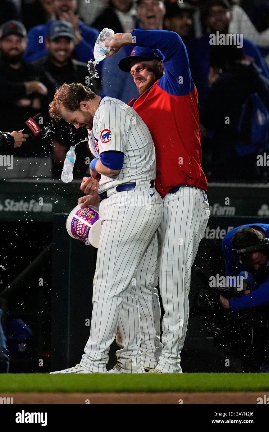Chicago Cubs' Ian Happ (8), left, is doused with water as his team ...