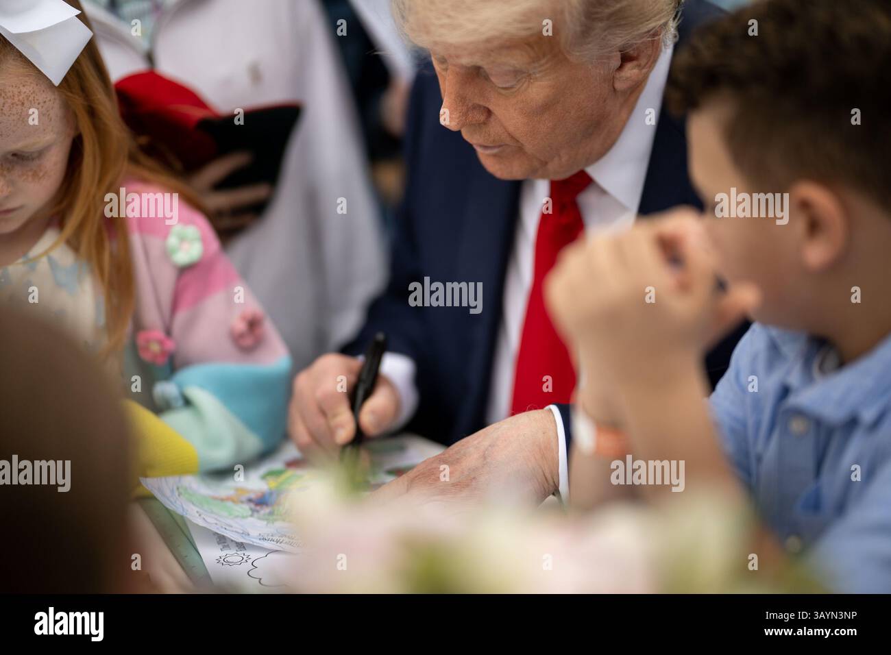 President Donald Trump colors with children at the White House Easter ...