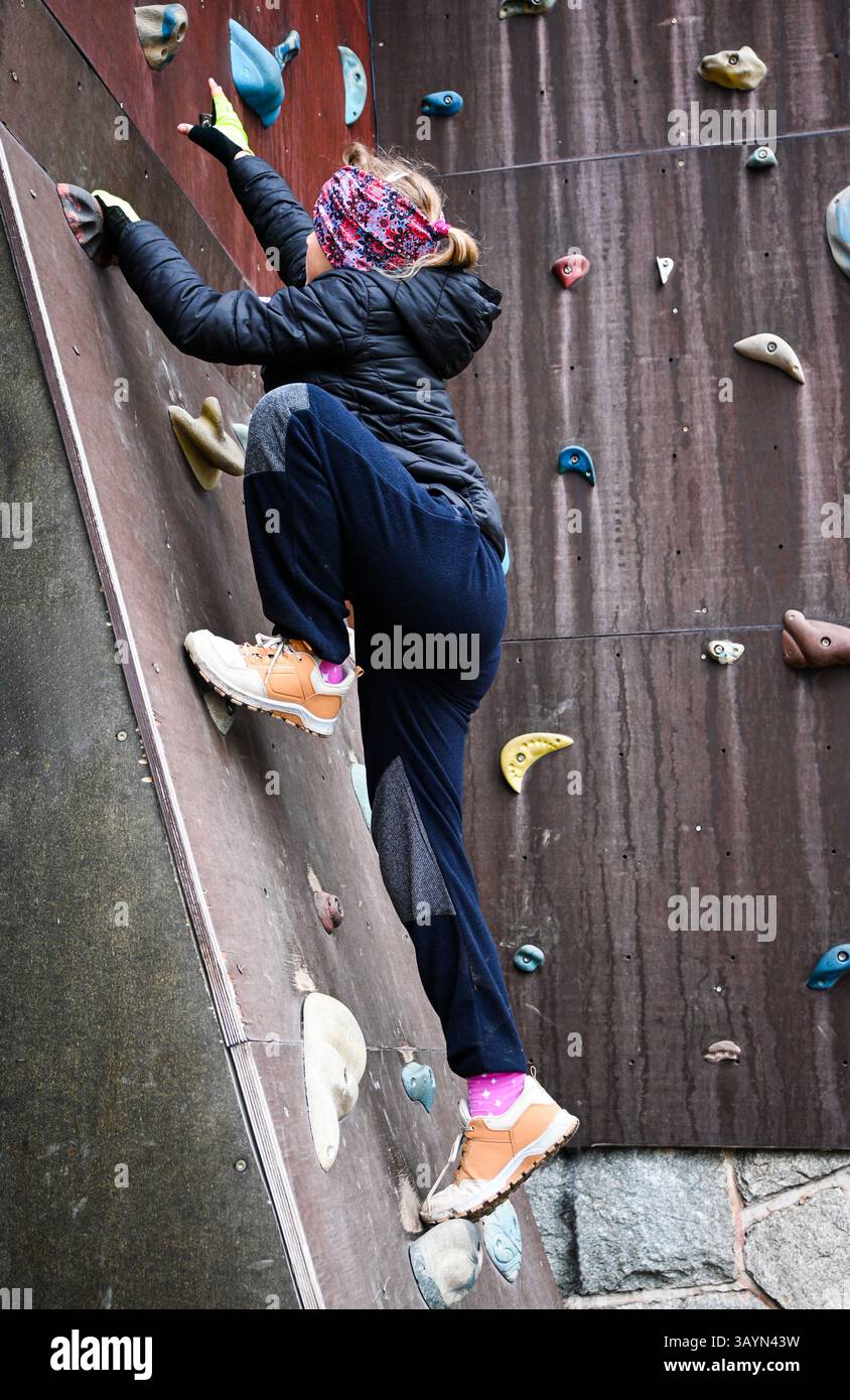 Girl practicing on a climbing wall, demonstrating strength, agility ...