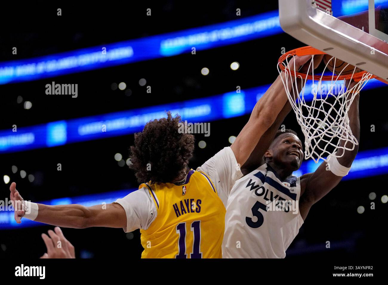 Minnesota Timberwolves guard Anthony Edwards (5) dunks over Los Angeles Lakers center Jaxson ...