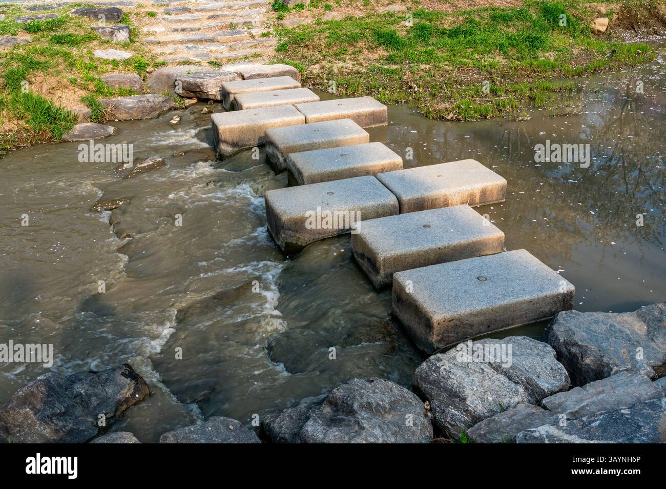 A serene natural scene of a shallow stream flowing gently through the ...