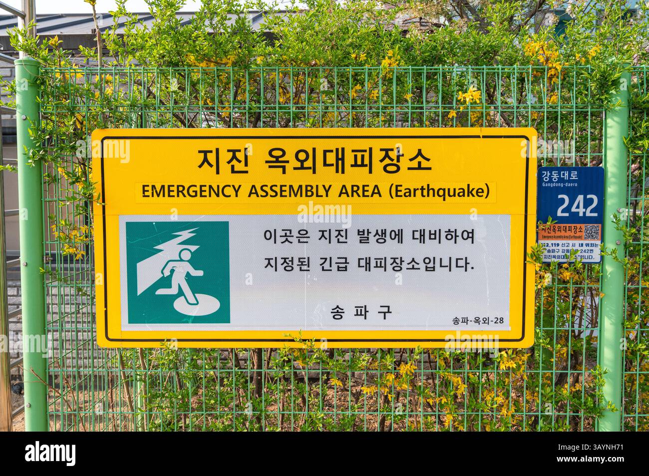 A yellow sign indicating an outdoor emergency assembly area in case of ...