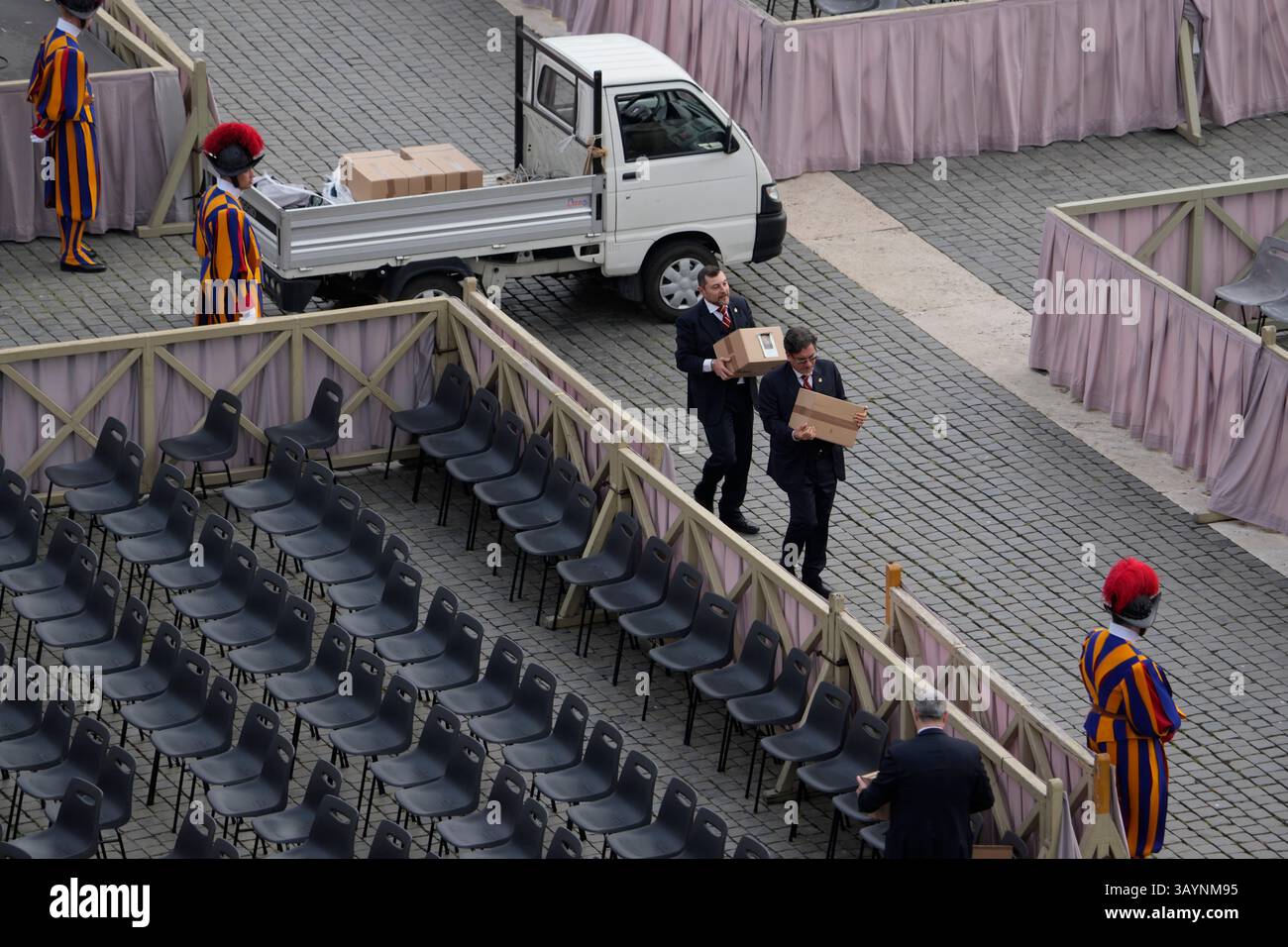 Two men carry boxes during the preparations in St. Peter's Square ahead ...