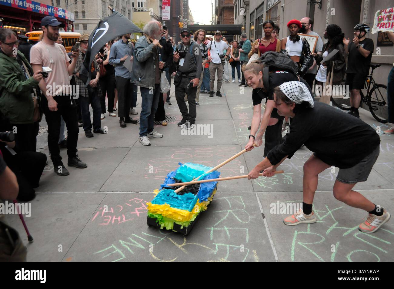 New York, USA. 22nd Apr, 2025. Climate activists break a piñata of a ...