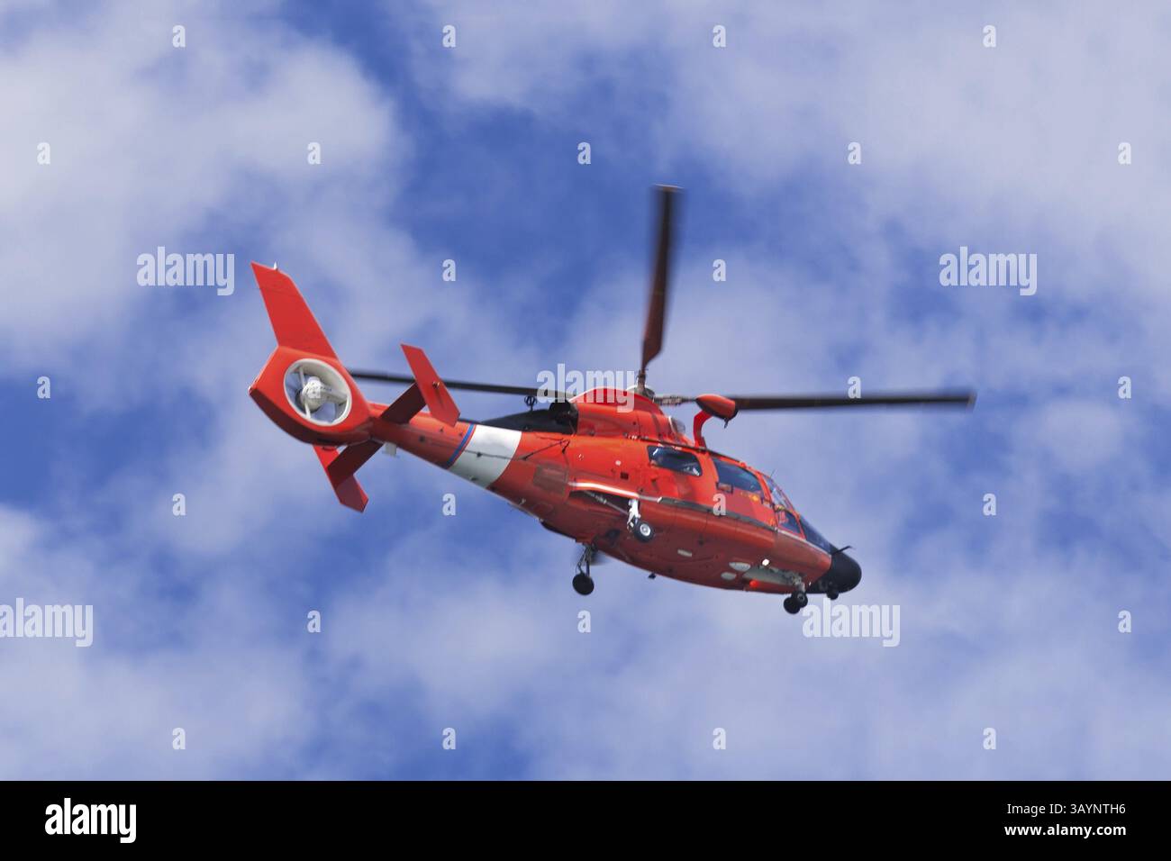 Red rescue helicopter moving in blue sky with blur propeller Stock ...