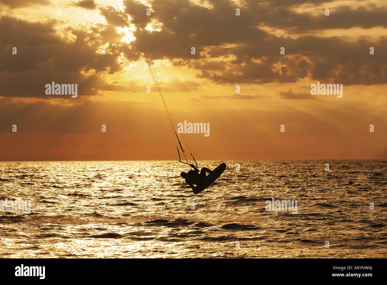 Kite surfer jumping from the water at sunset ocean Stock Photo - Alamy