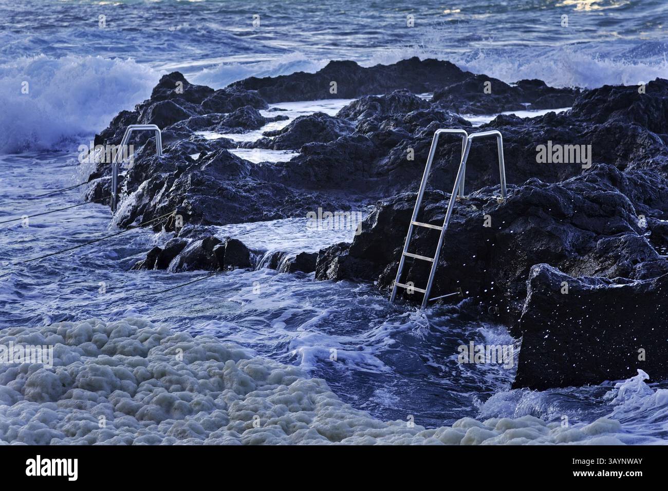 Ocean waves and stairs in public pool of Termas da Ferraria, Sao Miguel ...