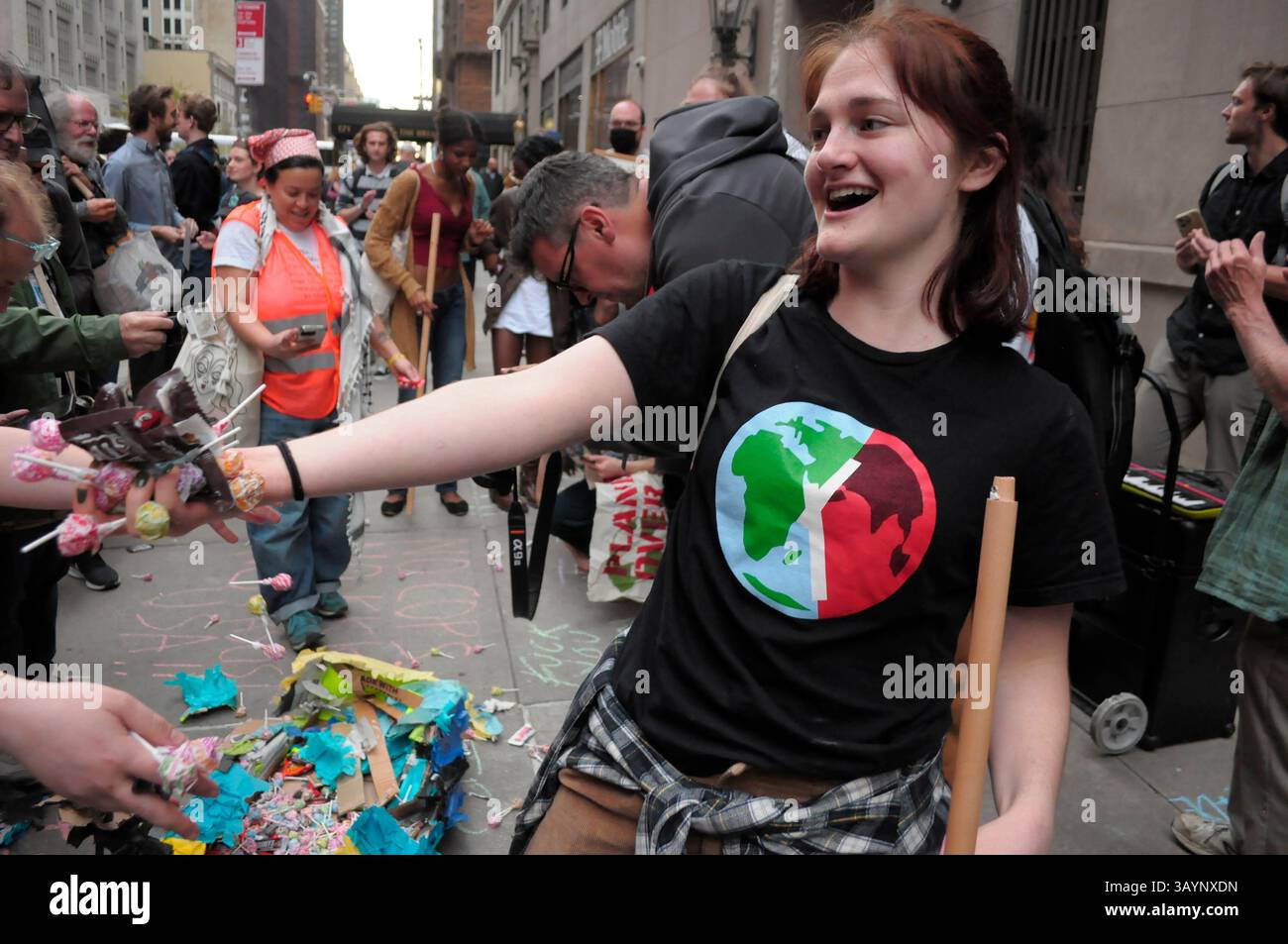 A climate activist hands out candy from a piñata of a Tesla Cybertruck ...