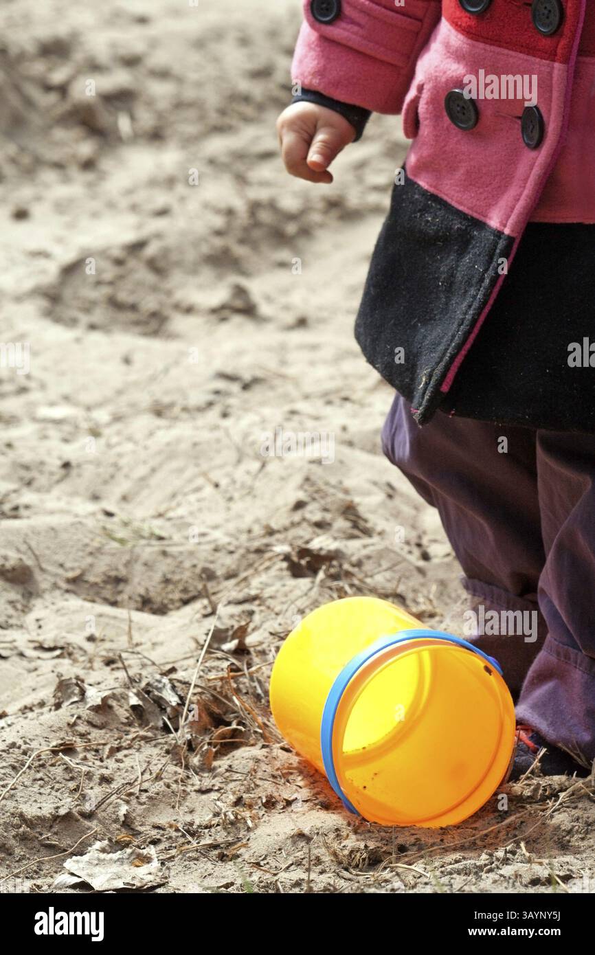 Kid's hand and toy bucket in sand Stock Photo - Alamy
