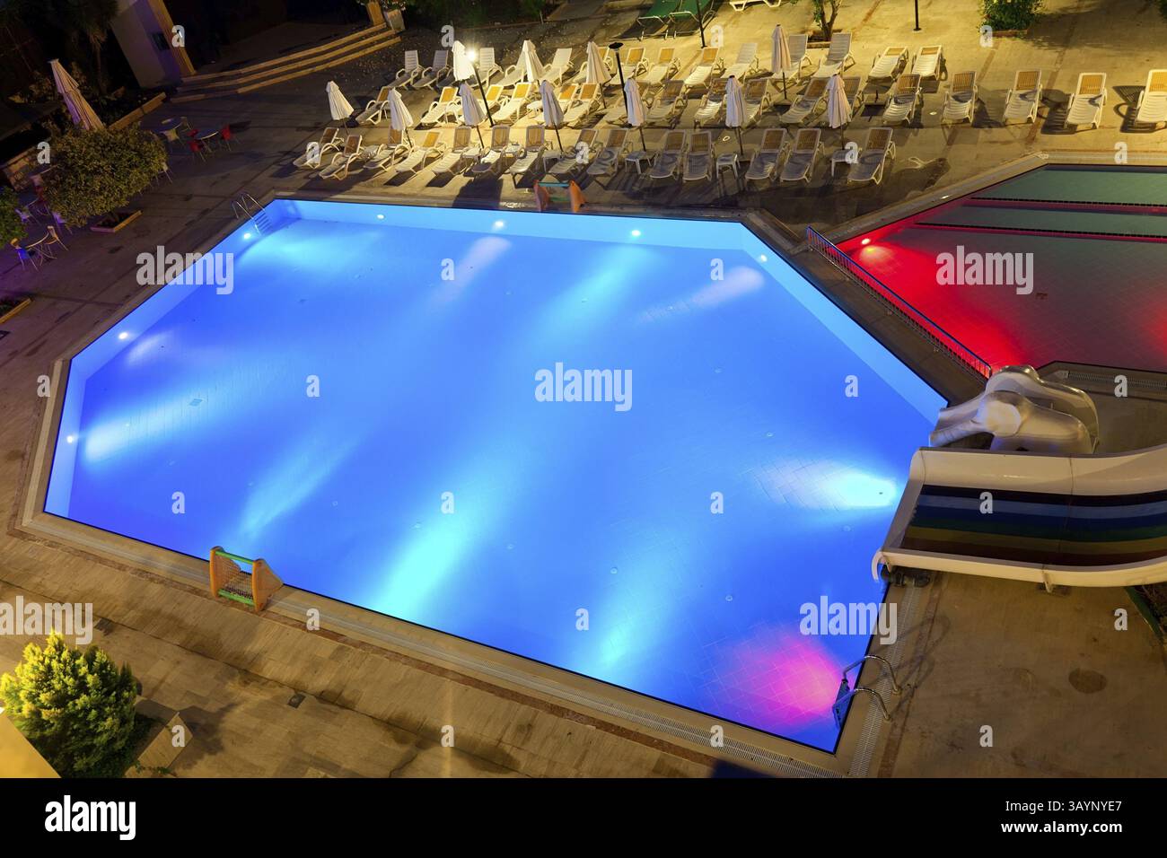Illuminated swimming pool at night on tropical resort Stock Photo - Alamy