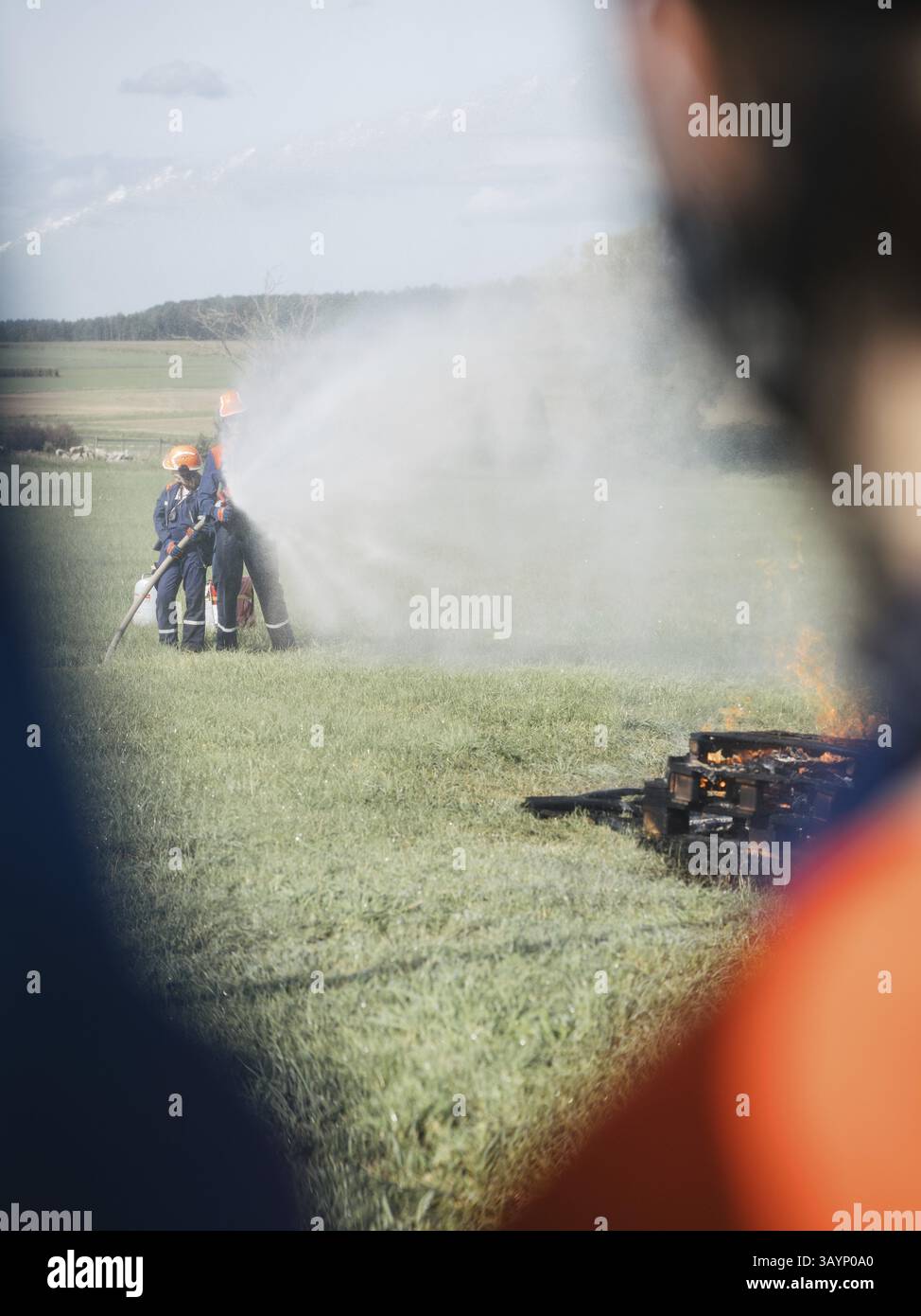 Firefighters fighting a confined fire in a meadow, photographed with a ...