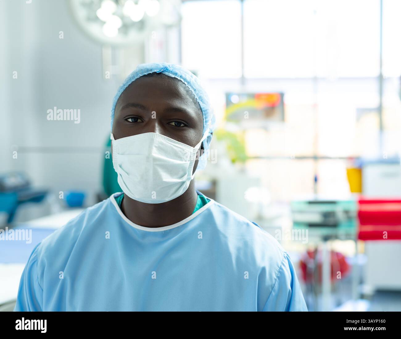 African American male surgeon standing in operating room, wearing blue ...