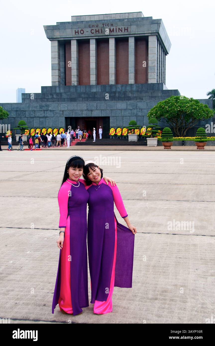 Vietnamese girls posing in ao dai (national costume) in front of the Ho Chi Minh Mausoluem in ...