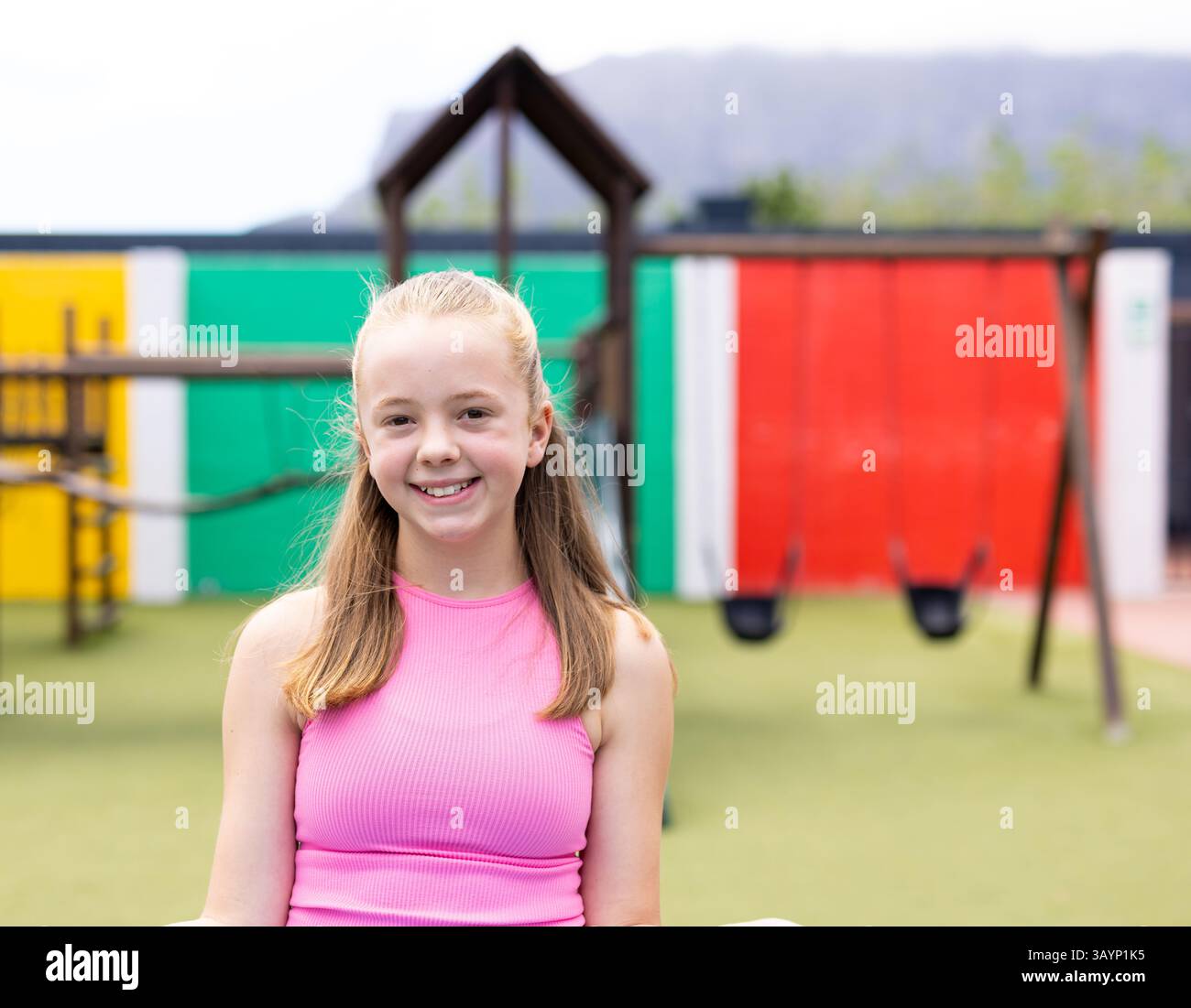 Eight-year-old girl smiling at children's playground with wooden ...