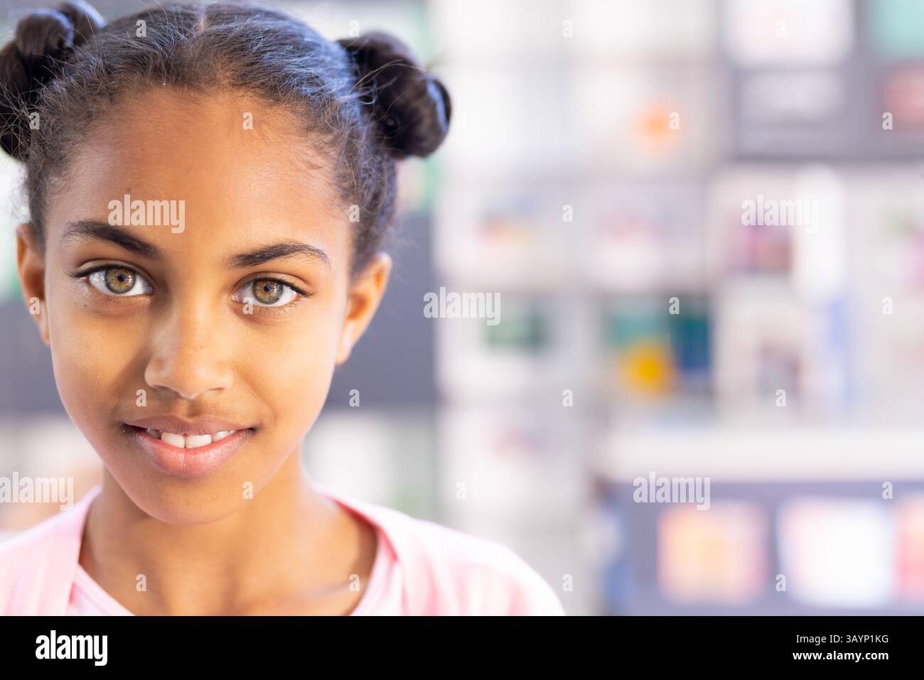 pre-teen African American girl smiling in classroom library with books ...