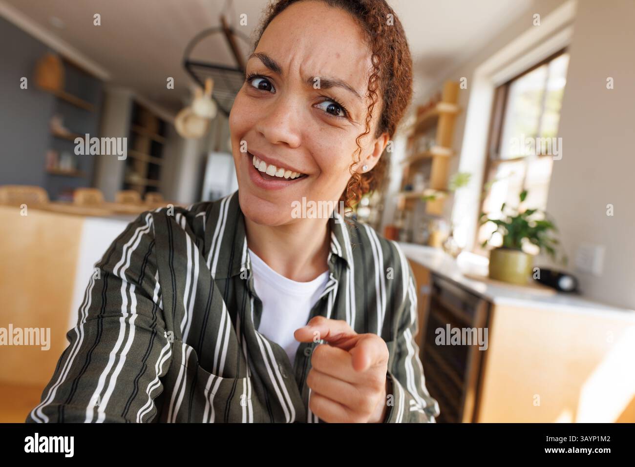 Woman taking close-up selfie in modern kitchen with dining table ...