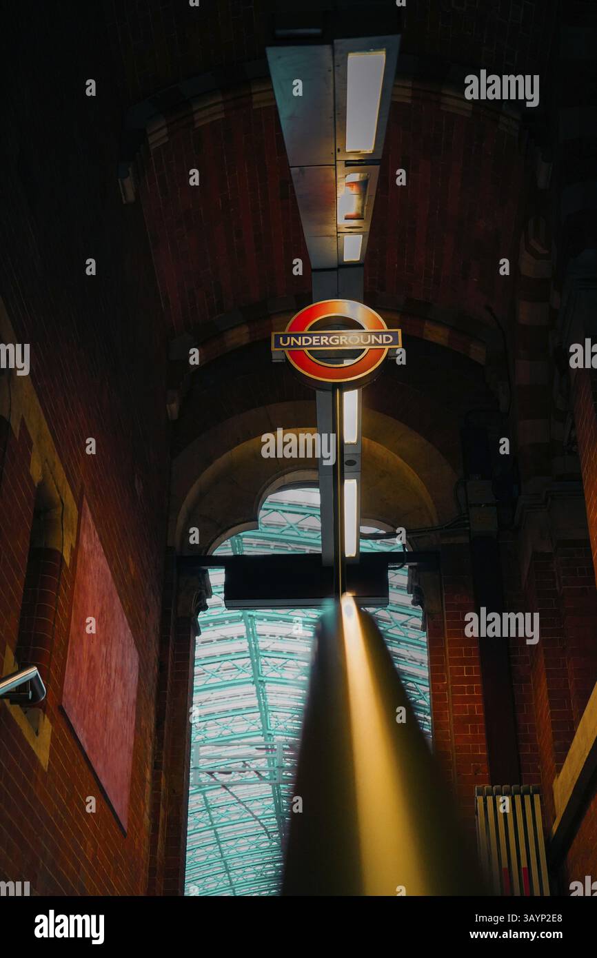 London Underground sign in a brick building with light coming through ...