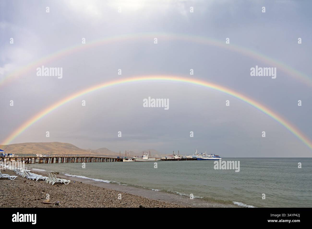 Double rainbow on sea beach above the pier Stock Photo - Alamy