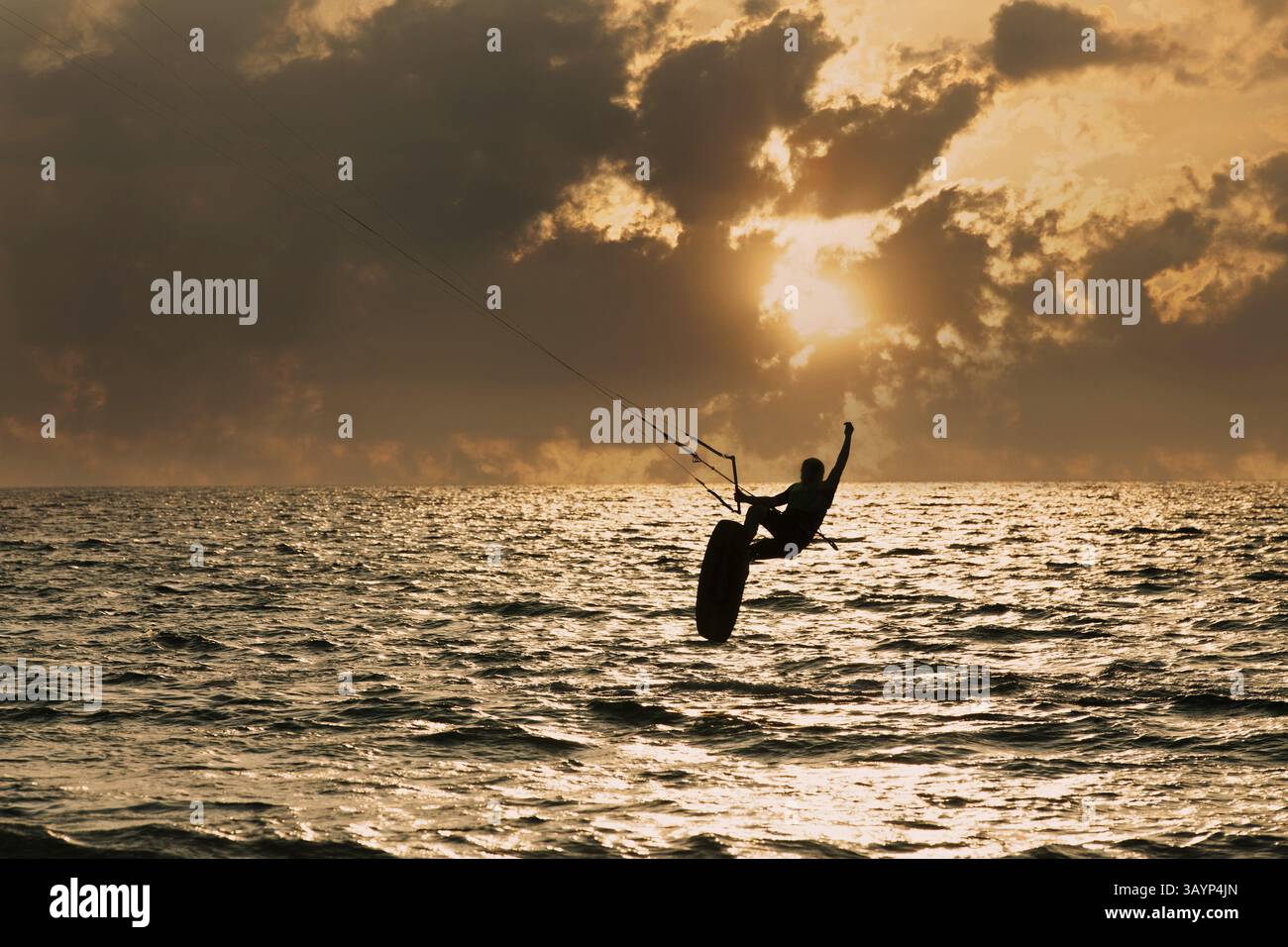 Kite surfer jumping from the water at sunset ocean Stock Photo - Alamy