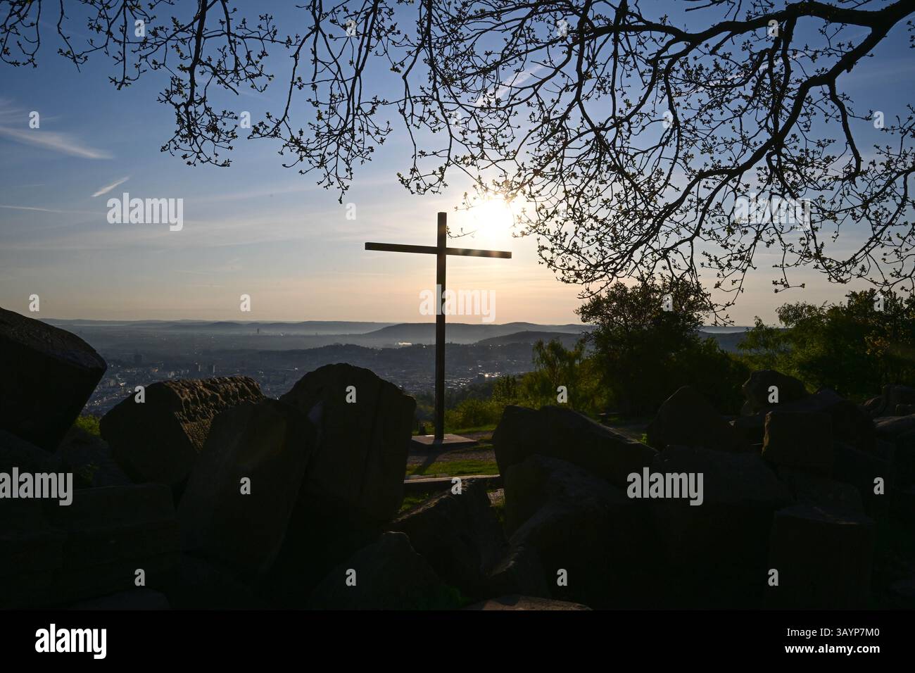 Stuttgart, Germany. 23rd Apr, 2025. The sun rises in front of a cross ...