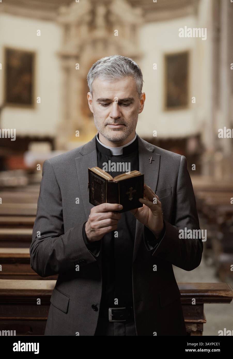 Portrait of a priest reading the gospel inside a church Stock Photo - Alamy