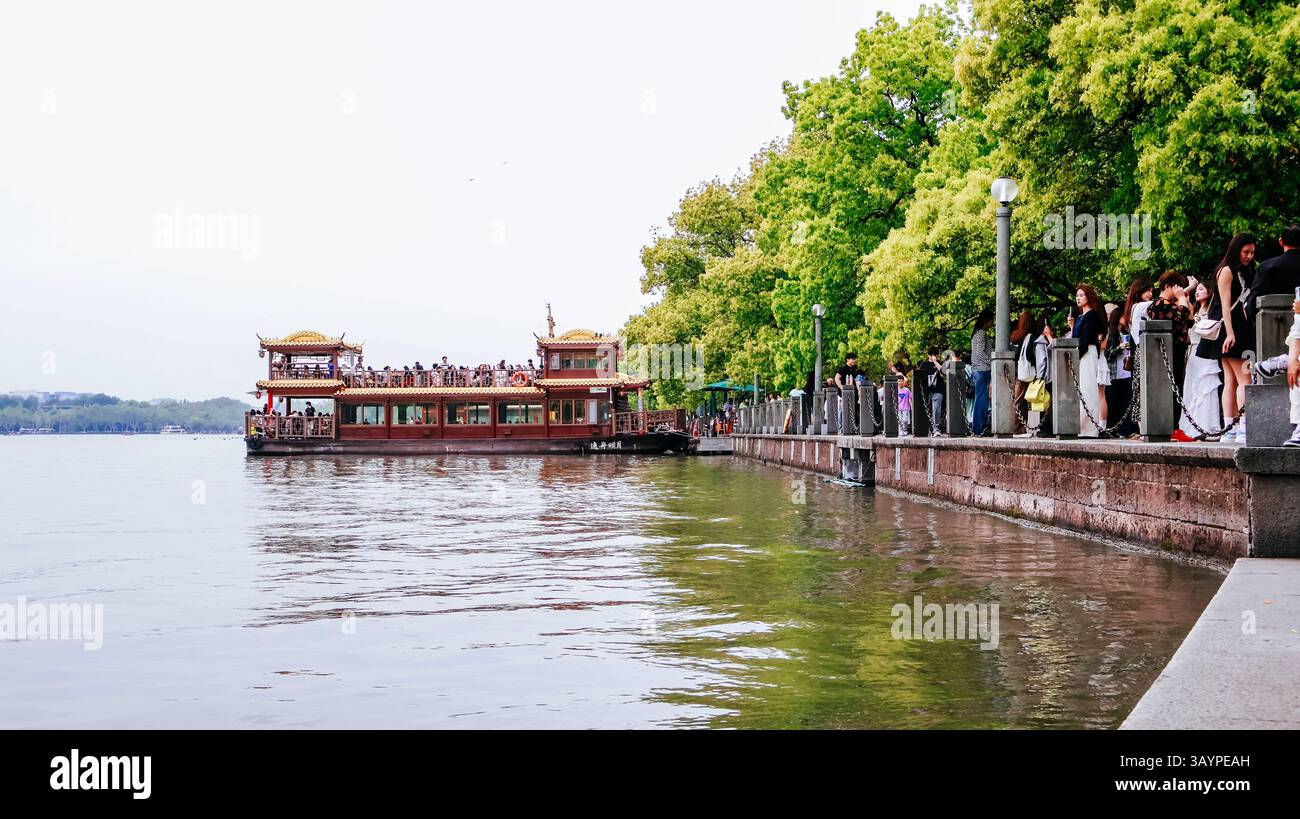 Scenic view of a traditional Chinese boat cruising on West Lake with ...