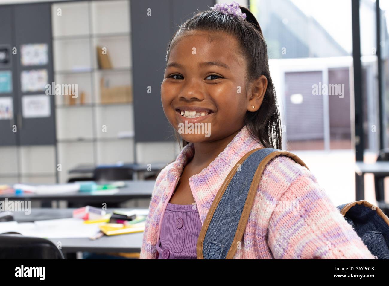 girl child standing and smiling in elementary school classroom, with ...