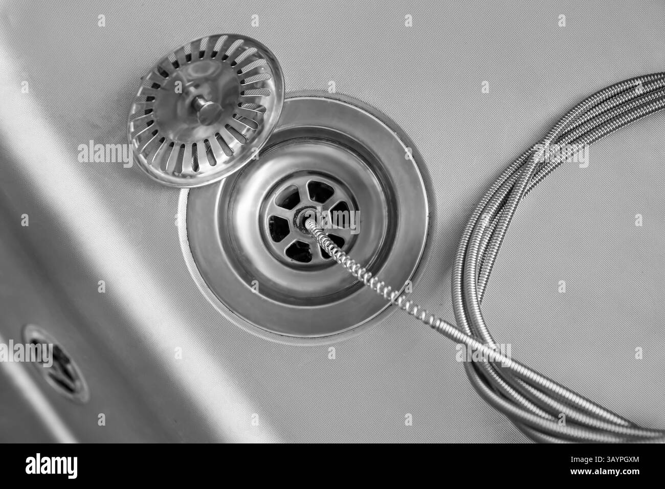 Cleaning of drain with plumber's snake, closeup Stock Photo - Alamy