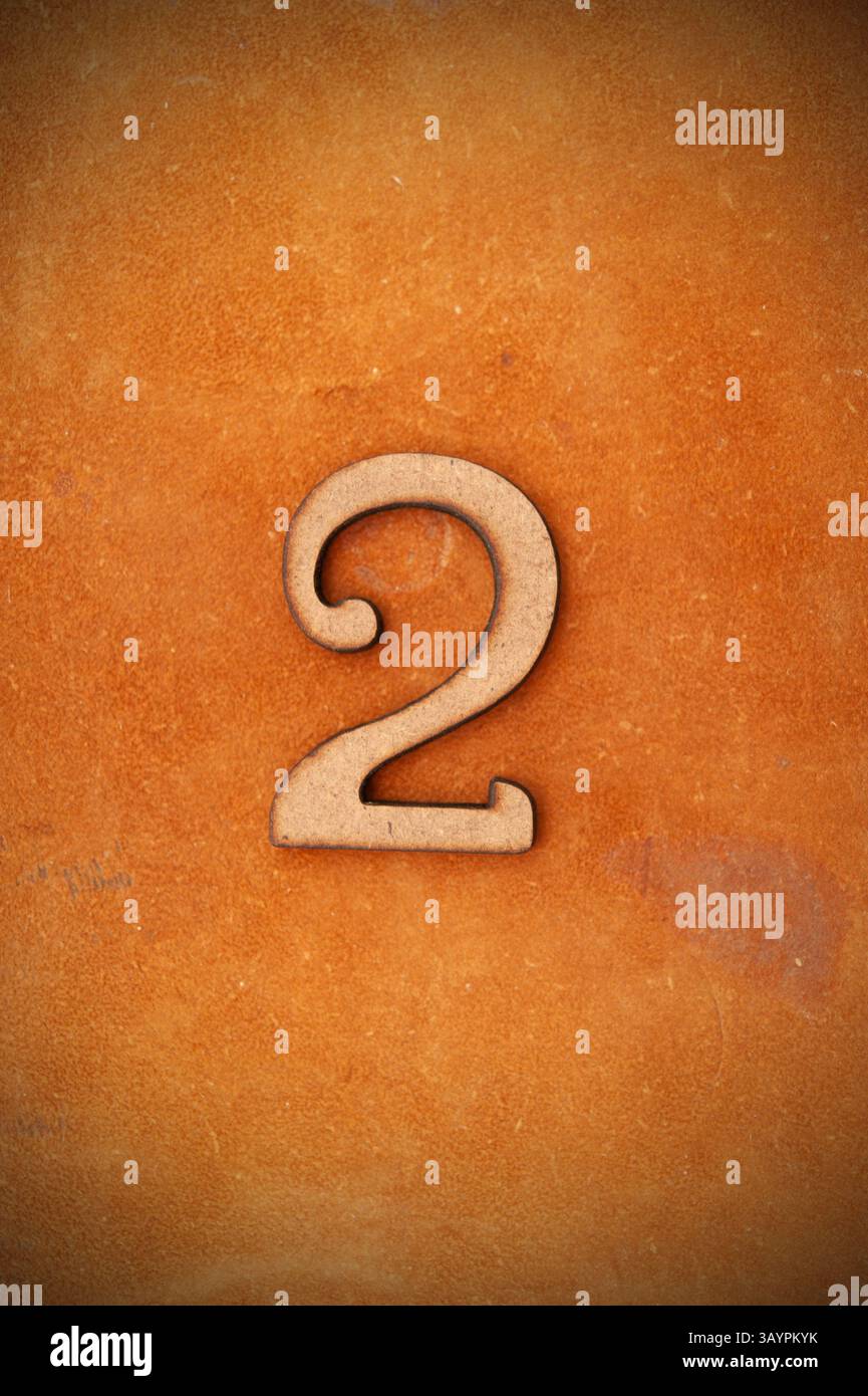 wooden number two on a brown backdrop, part of a set of single digits ...